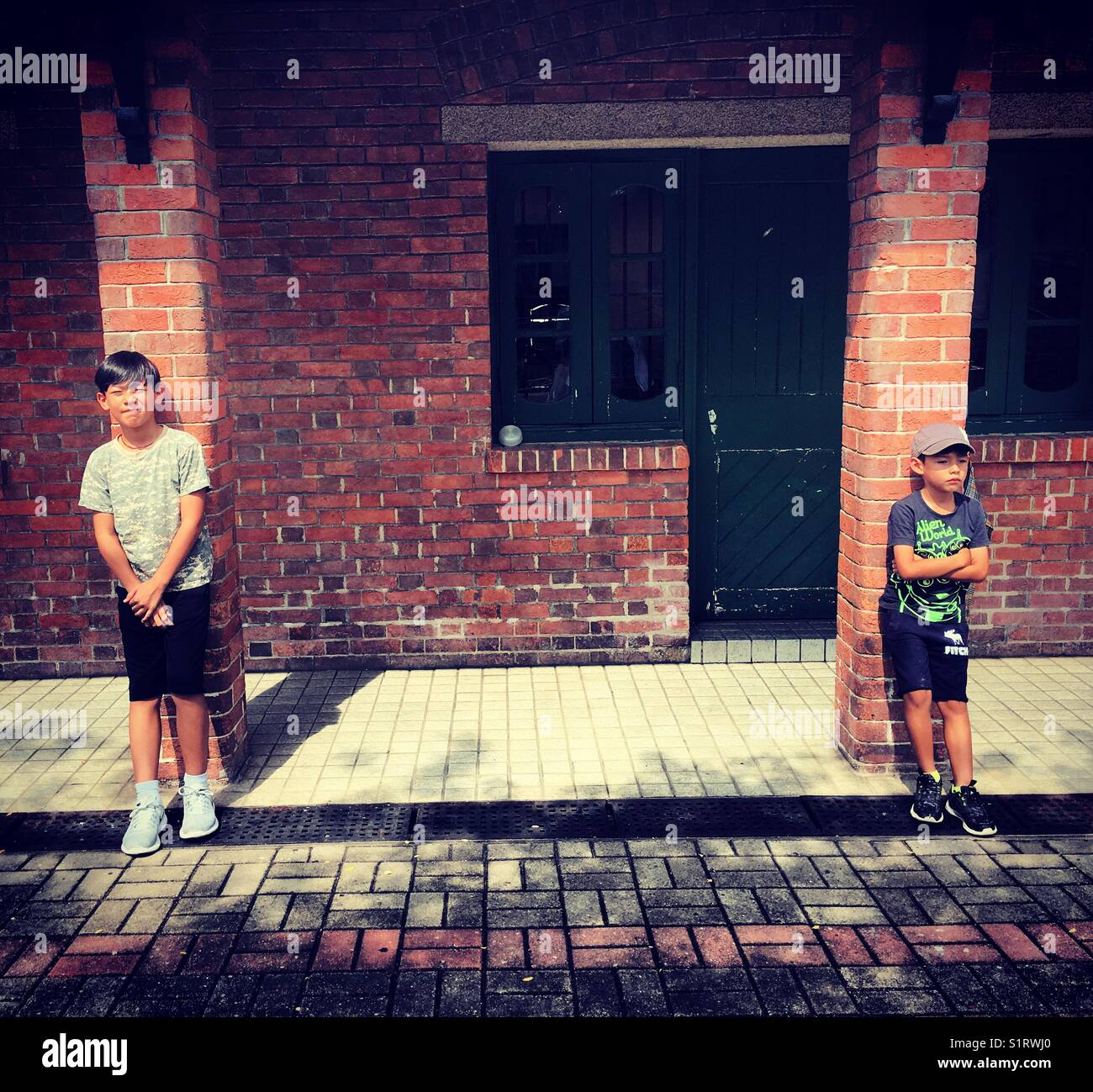 Two boys posing as guards in front of an old style chinese house in ...
