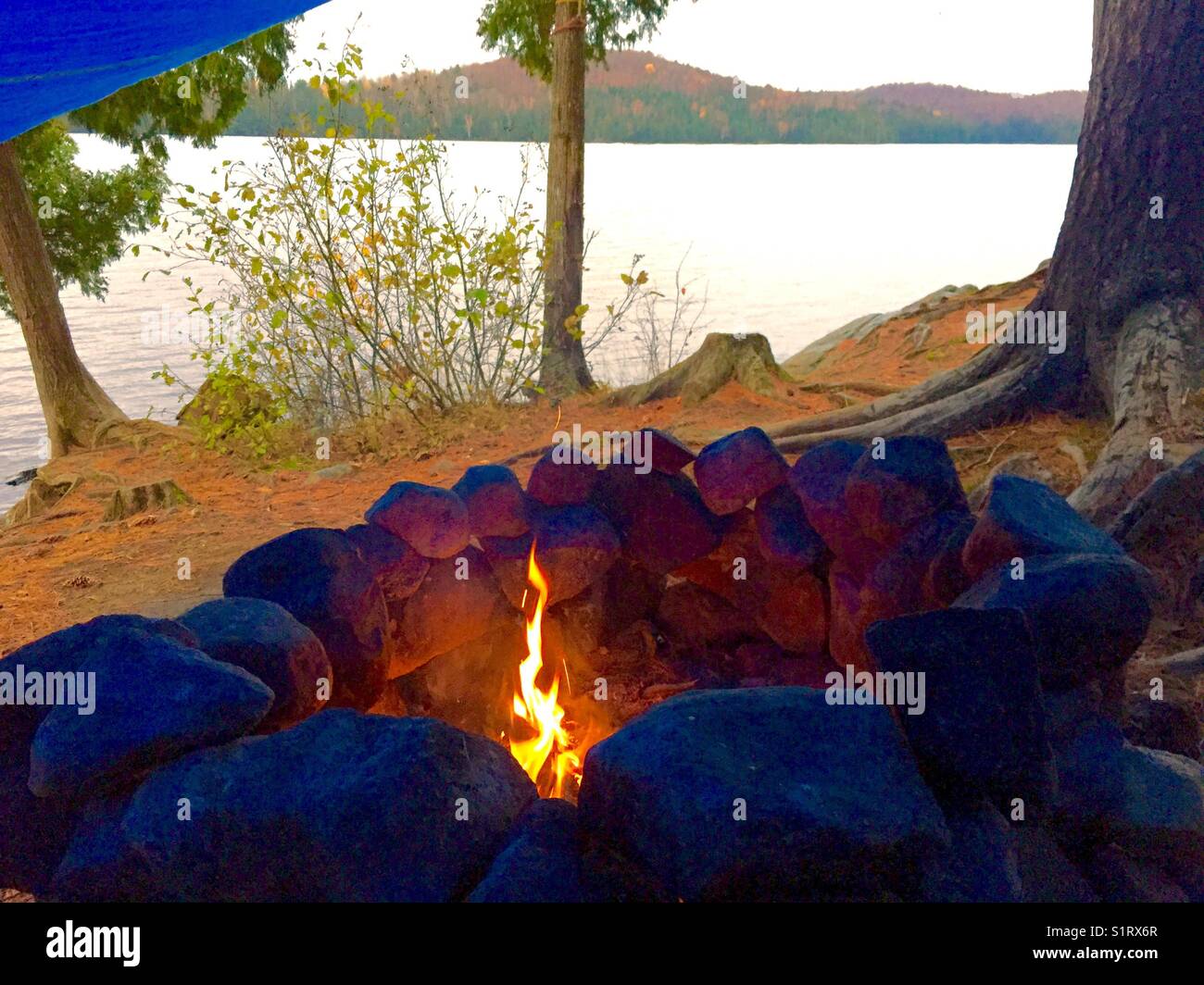 Campfire Burning Under Tarp On Rainy Autumn Day Stock Photo - Alamy