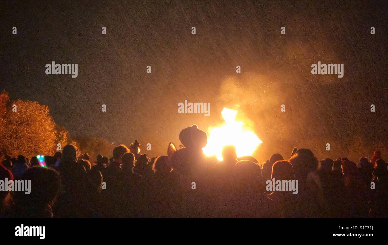 Crowd of people watching a large bonfire on 5th November in the pouring ...