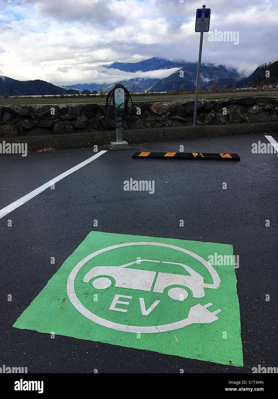 EV sign with mountains in backdrop Stock Photo - Alamy