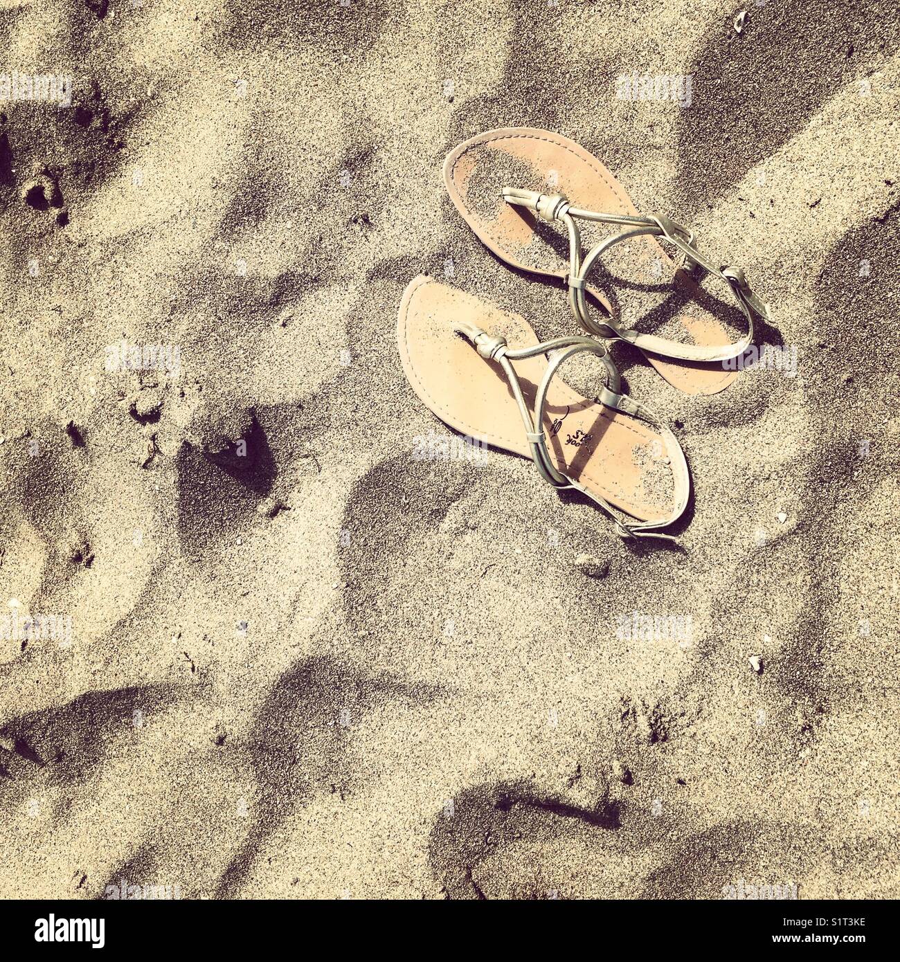 Sandals in the sand Stock Photo - Alamy