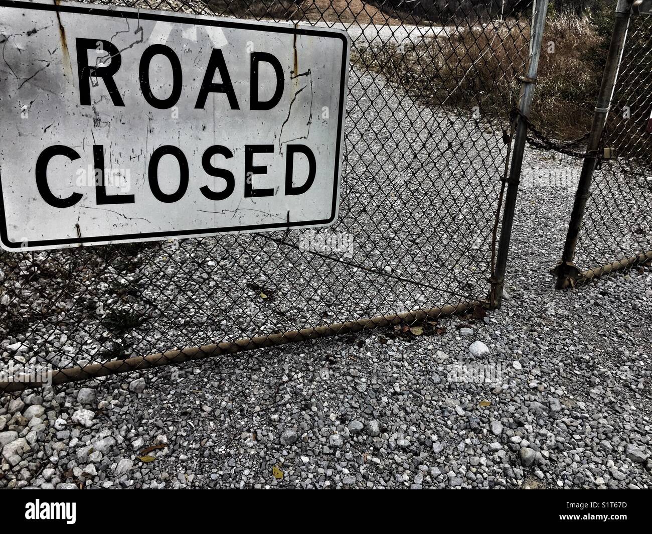 Road Closed Signage With Road Partially Blocked By Chain Link Fence