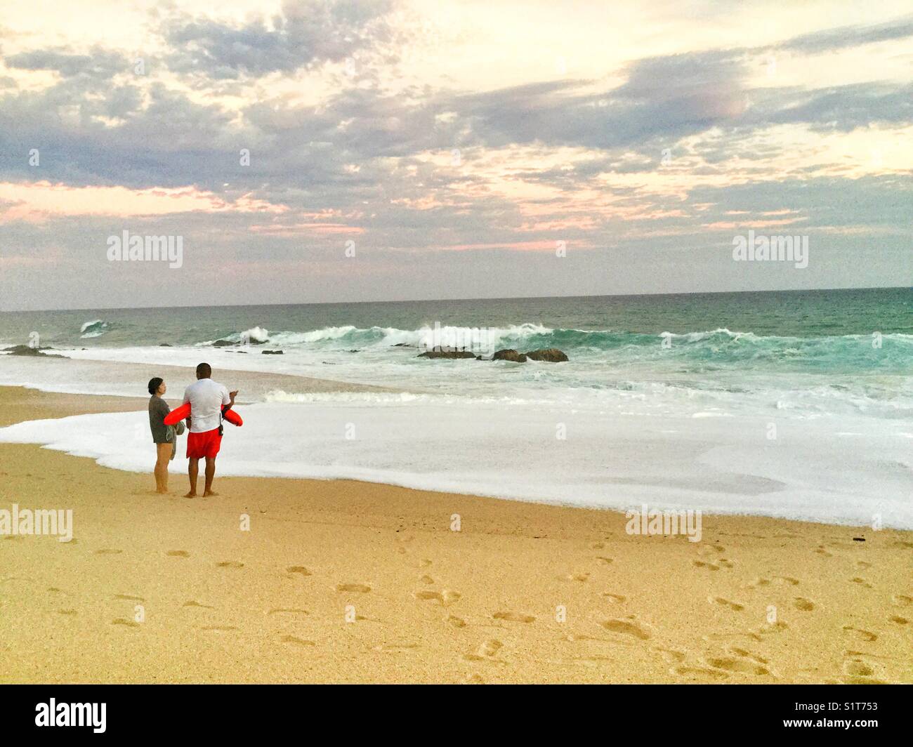 Lifeguard talking to a woman on the beach Stock Photo - Alamy