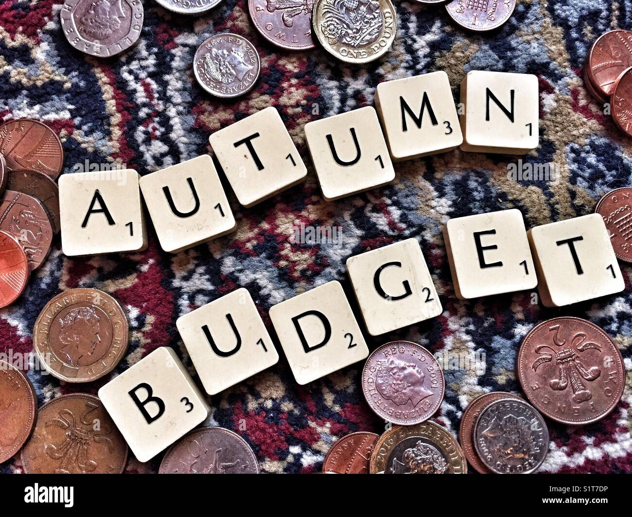 Autumn Budget written with Scrabble tiles surrounded with British coins ...