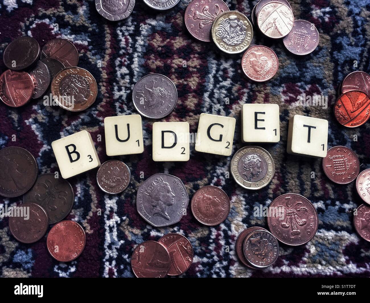 The word Budget written with Scrabble letters surrounded with coins ...