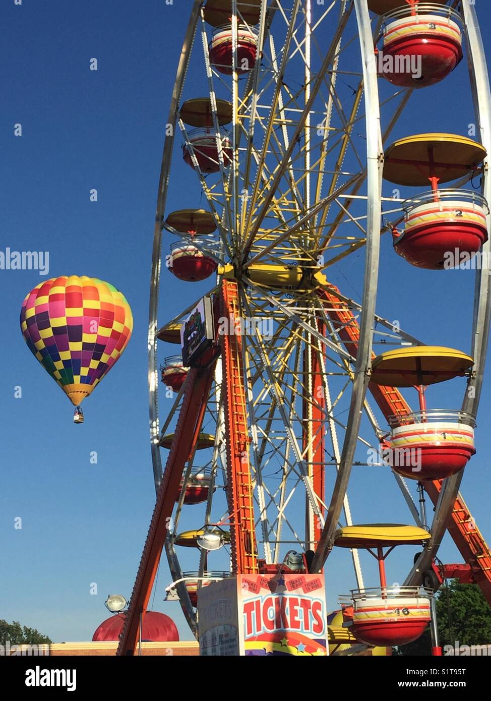 Hot air balloon behind carnival ferris wheel Stock Photo - Alamy