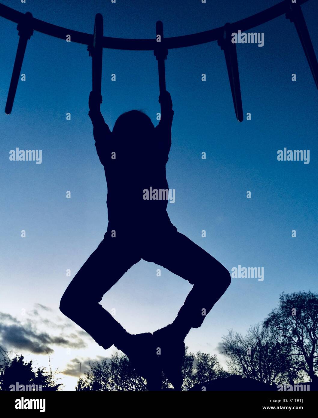 Child dangling from bar Stock Photo - Alamy