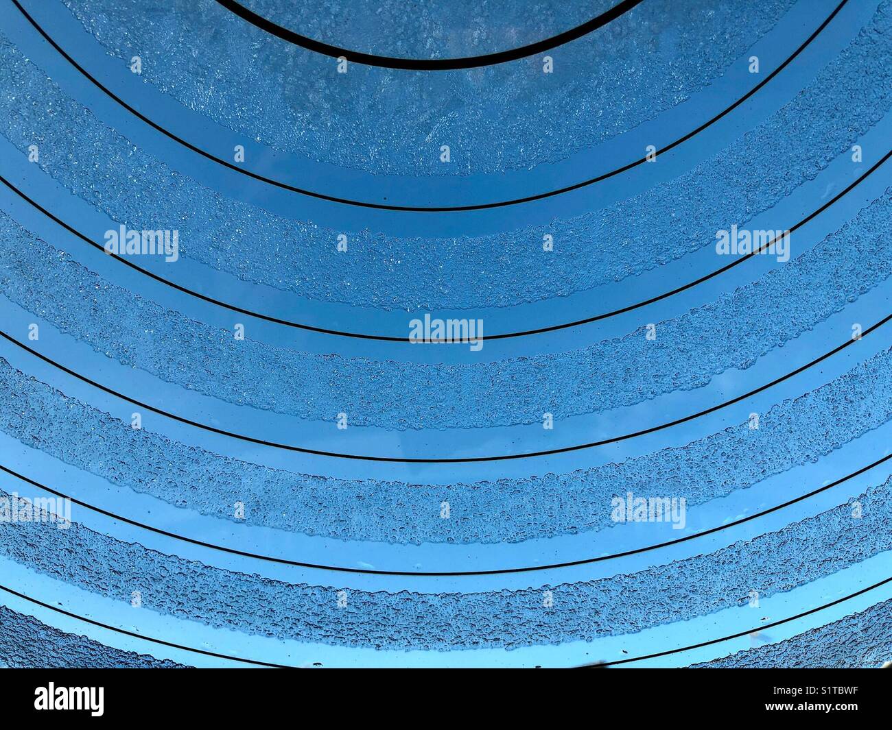 Frost melting on a heated rear window against a blue sky Stock Photo ...