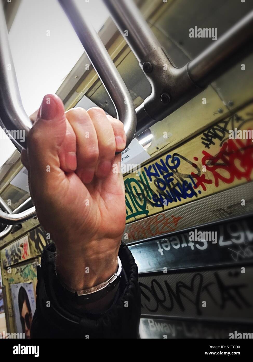 Strap hanger holding on to hand hold on vintage New York City subway ...