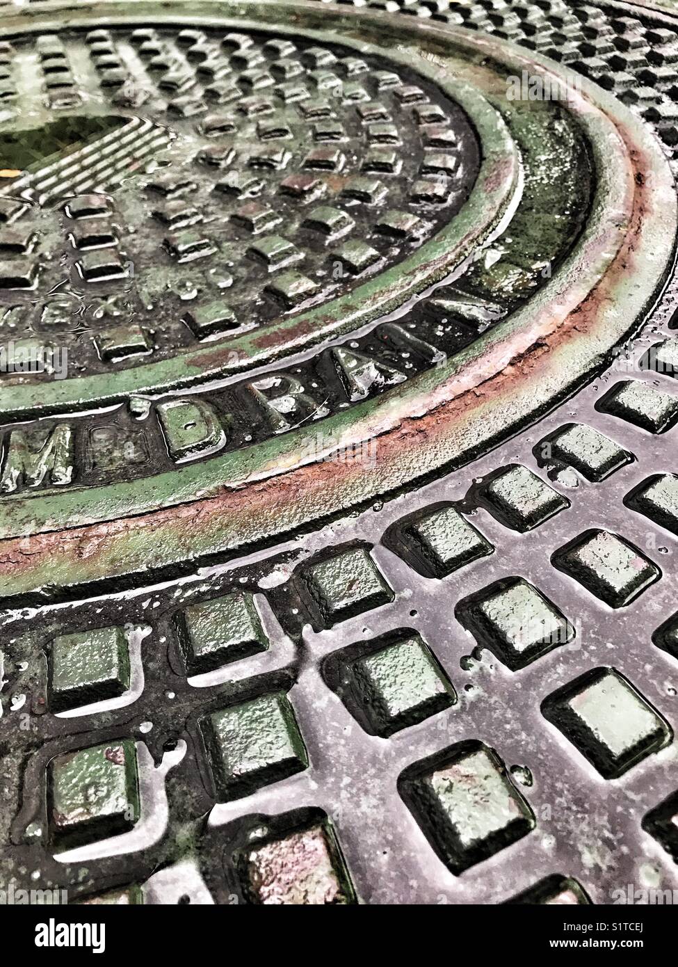 Wet storm drain cover Stock Photo - Alamy