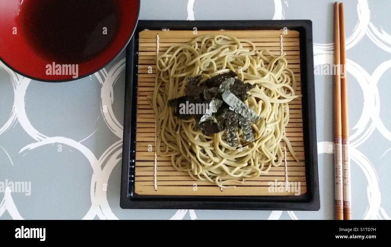 Cold soba on bamboo square plate, a bowl of miso soup, chopsticks on ...