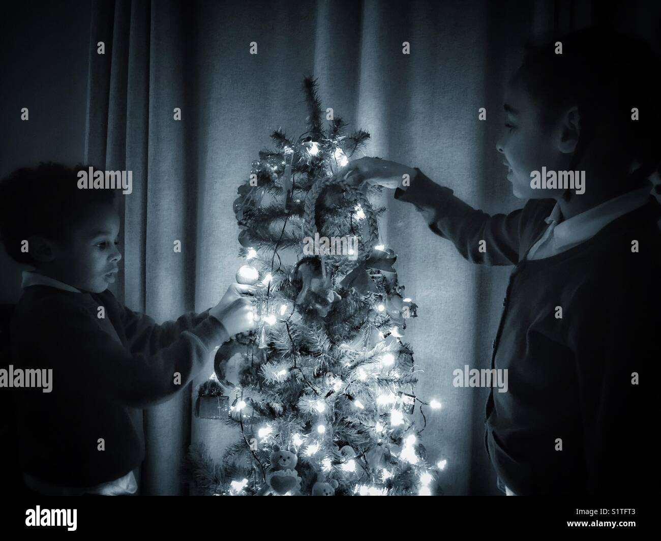 Kids decorating christmas tree hi-res stock photography and images - Alamy