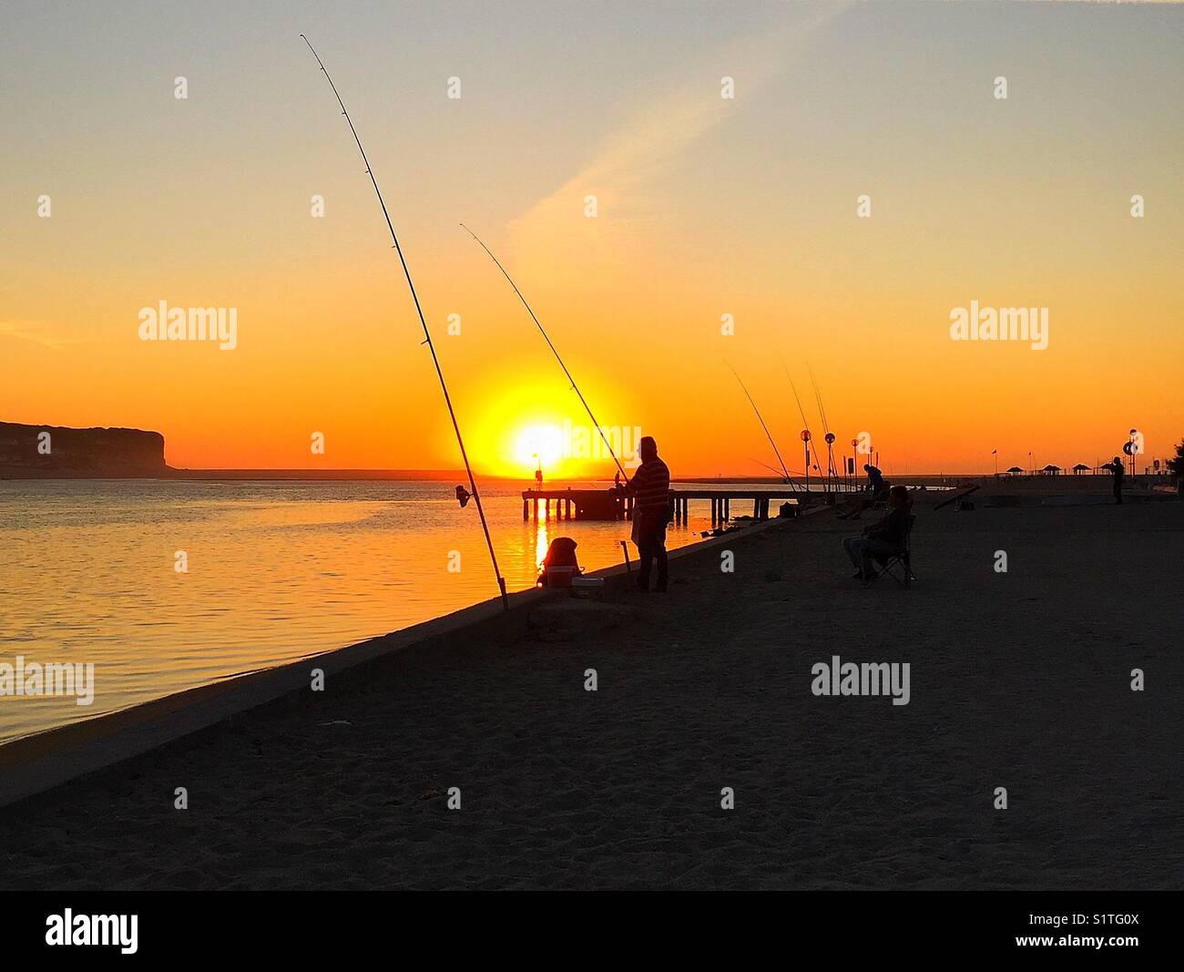 Fishermen at sunset Stock Photo - Alamy