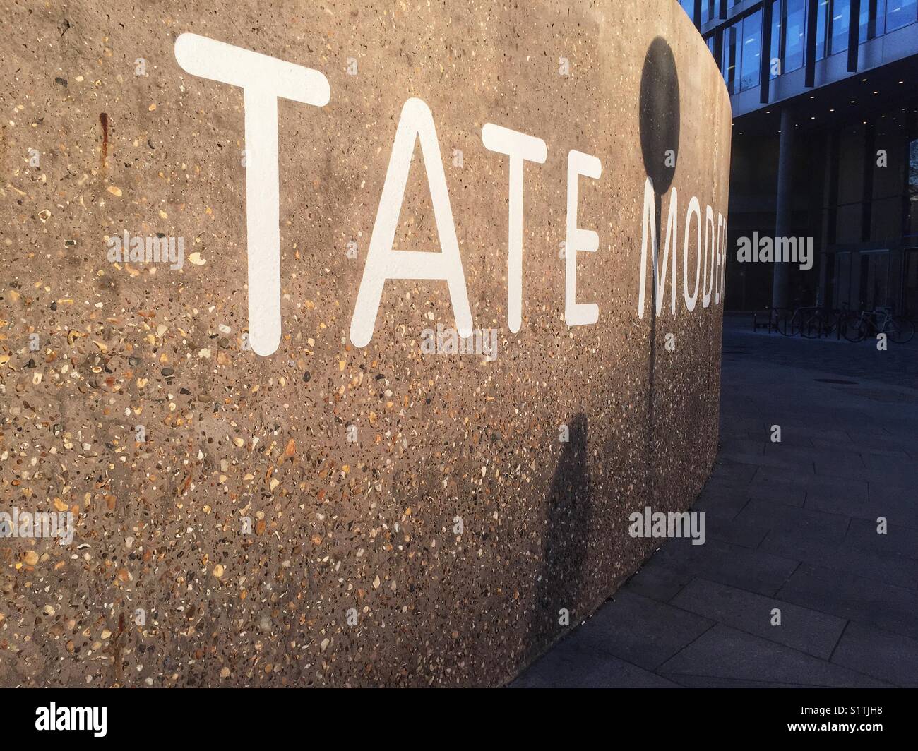 Shadows are seen on a Tate Modern sign on a wall outside Tate Modern in ...