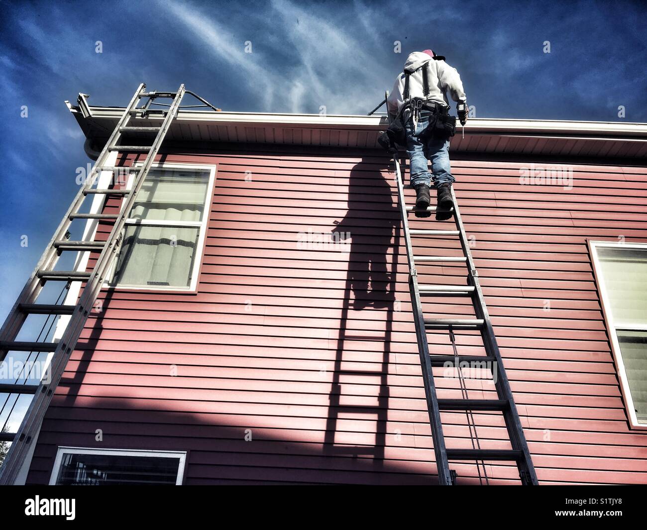 A worker fixing a gutters Stock Photo - Alamy