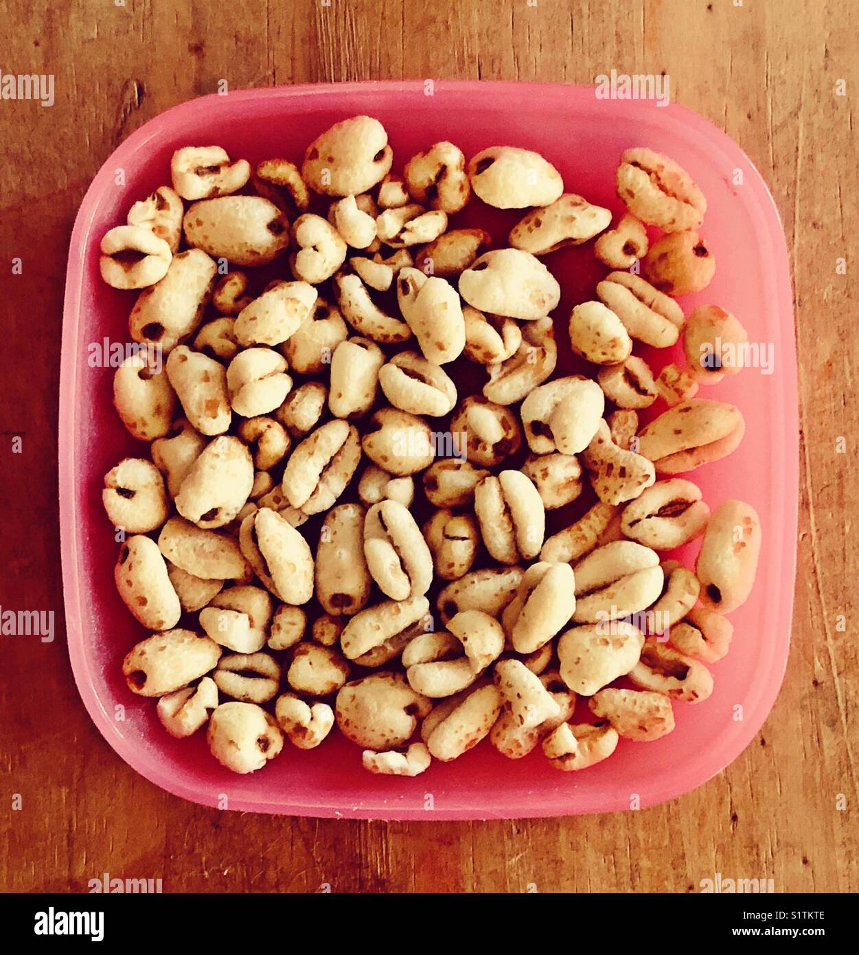 Puffed wheat puffs in a child’s small pink snack dish Stock Photo - Alamy