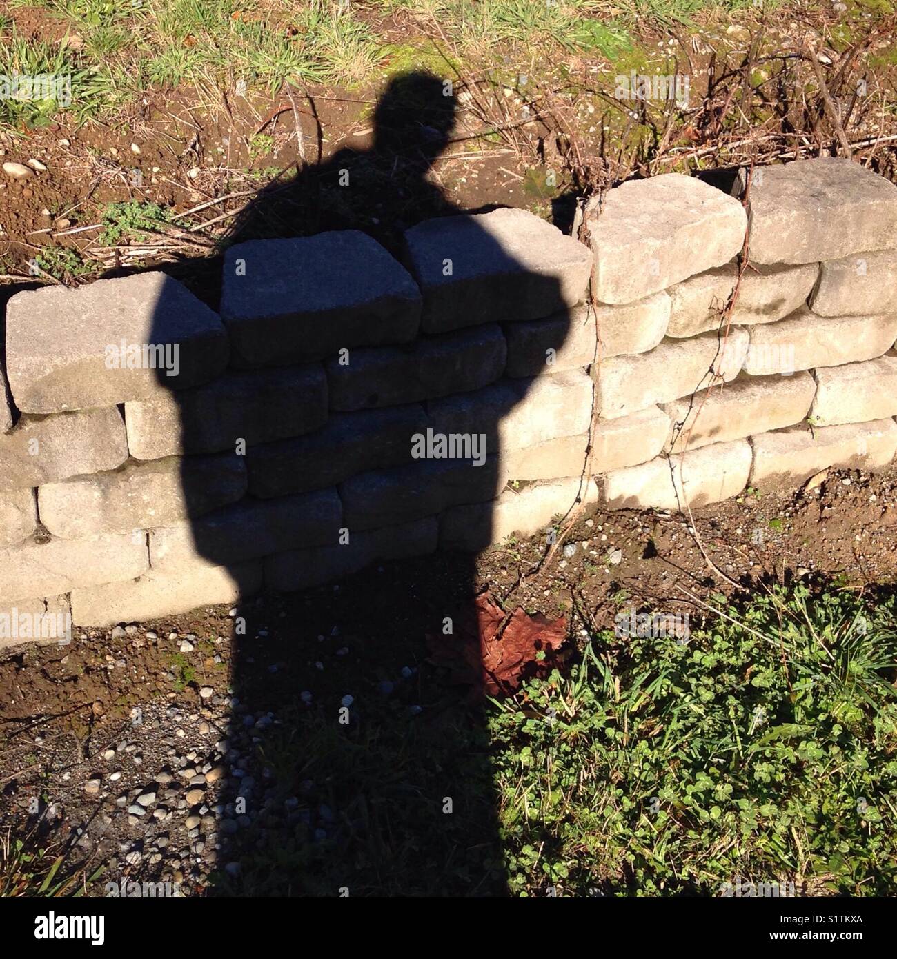 Shadow of an adult against a stone wall Stock Photo - Alamy