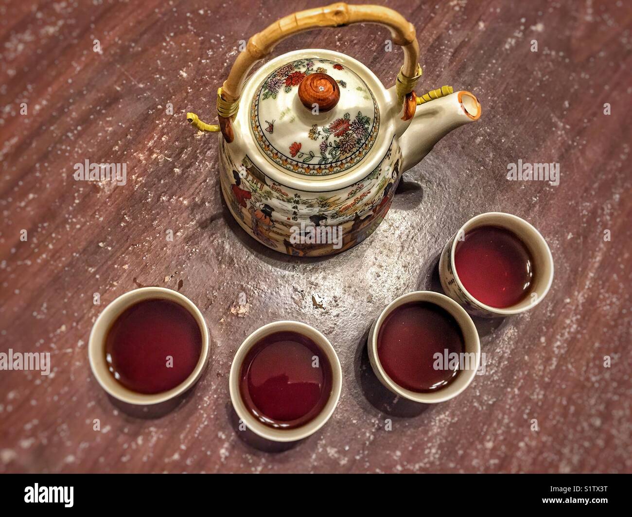 Chinese tea pot with four cups full of tea Stock Photo - Alamy