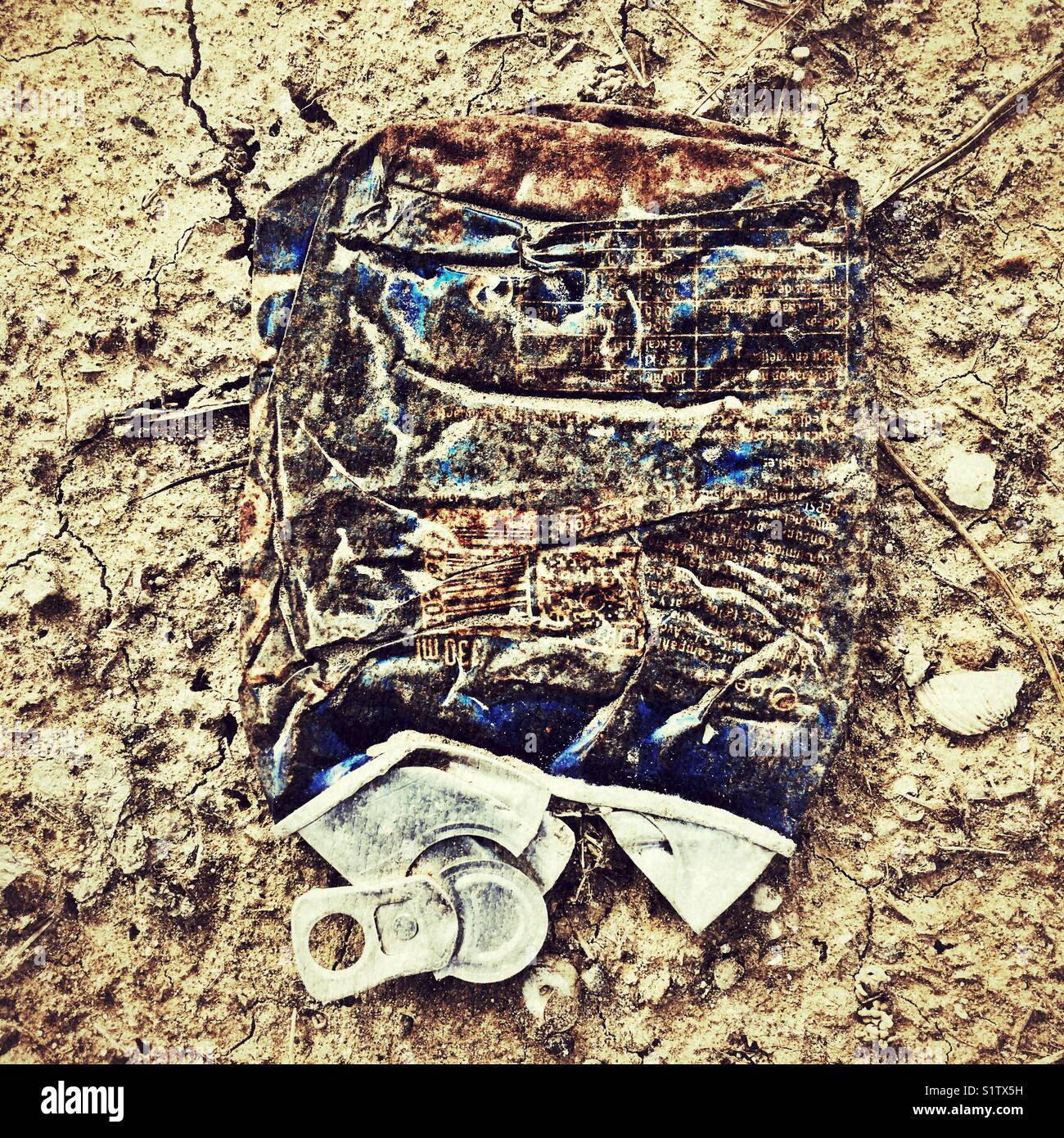 Pressed can on dirty ground Stock Photo - Alamy