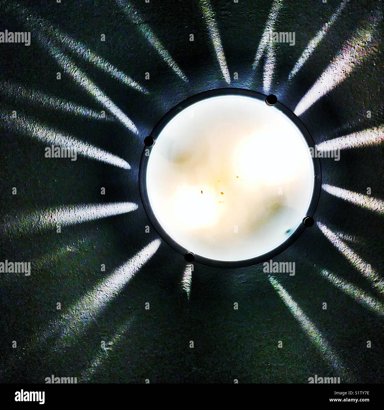 Lamp on the wall throwing light rays Stock Photo - Alamy