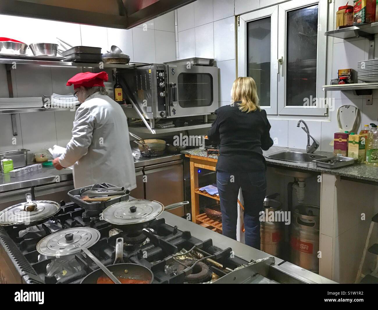 Chef and assistant preparing meals in a commercial kitchen Stock Photo ...