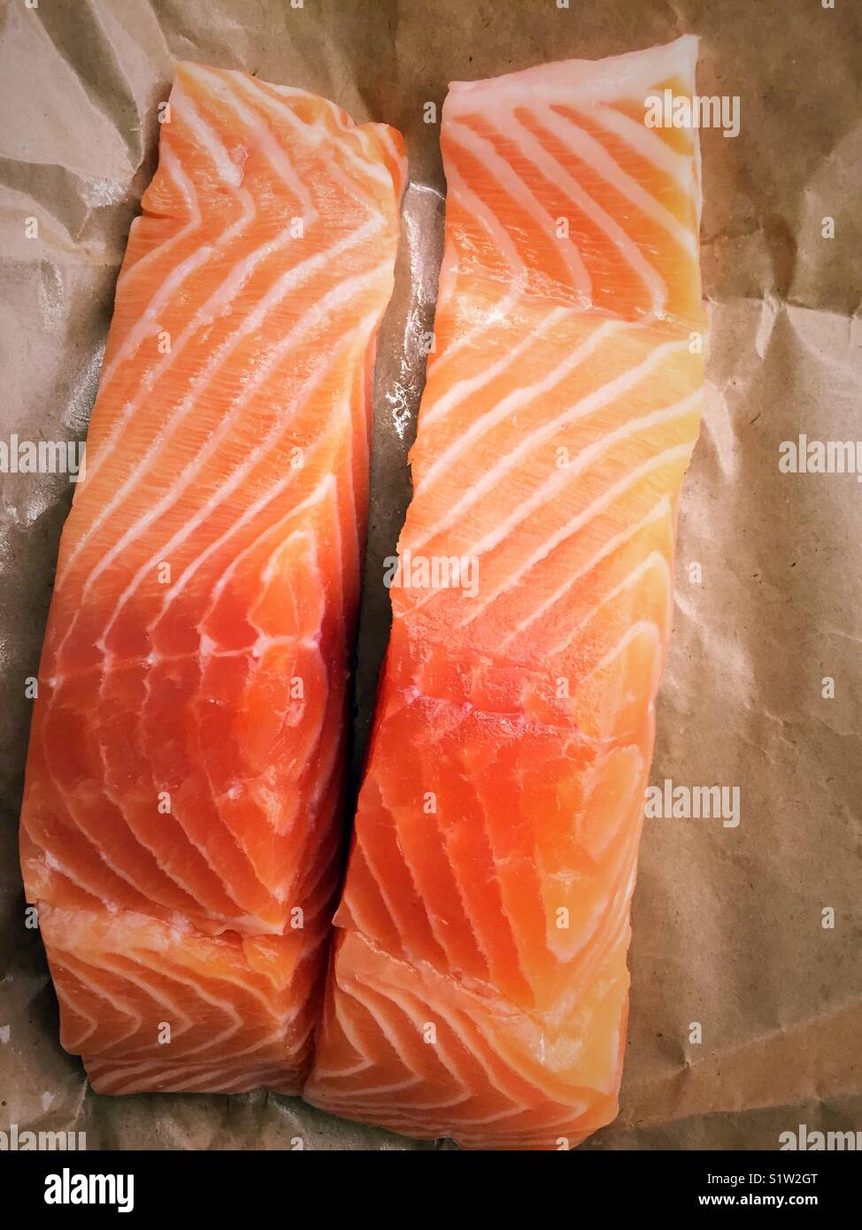 Two fresh salmon fillets on butcher paper close-up Stock Photo - Alamy