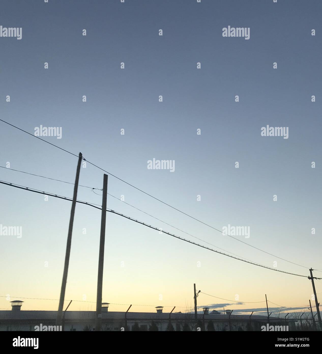 Blue early morning sky with electricity pylons Stock Photo - Alamy