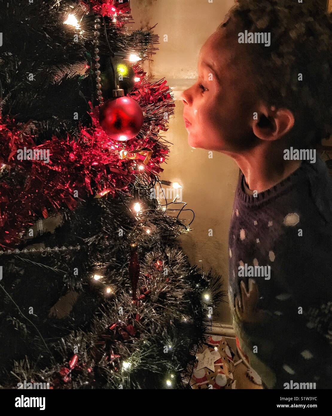 A child looking closely at Christmas tree decorations Stock Photo - Alamy