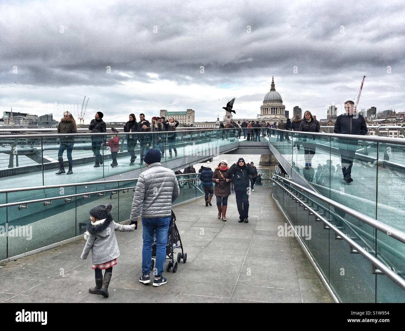People walk across the Millennium bridge in London, England on January ...