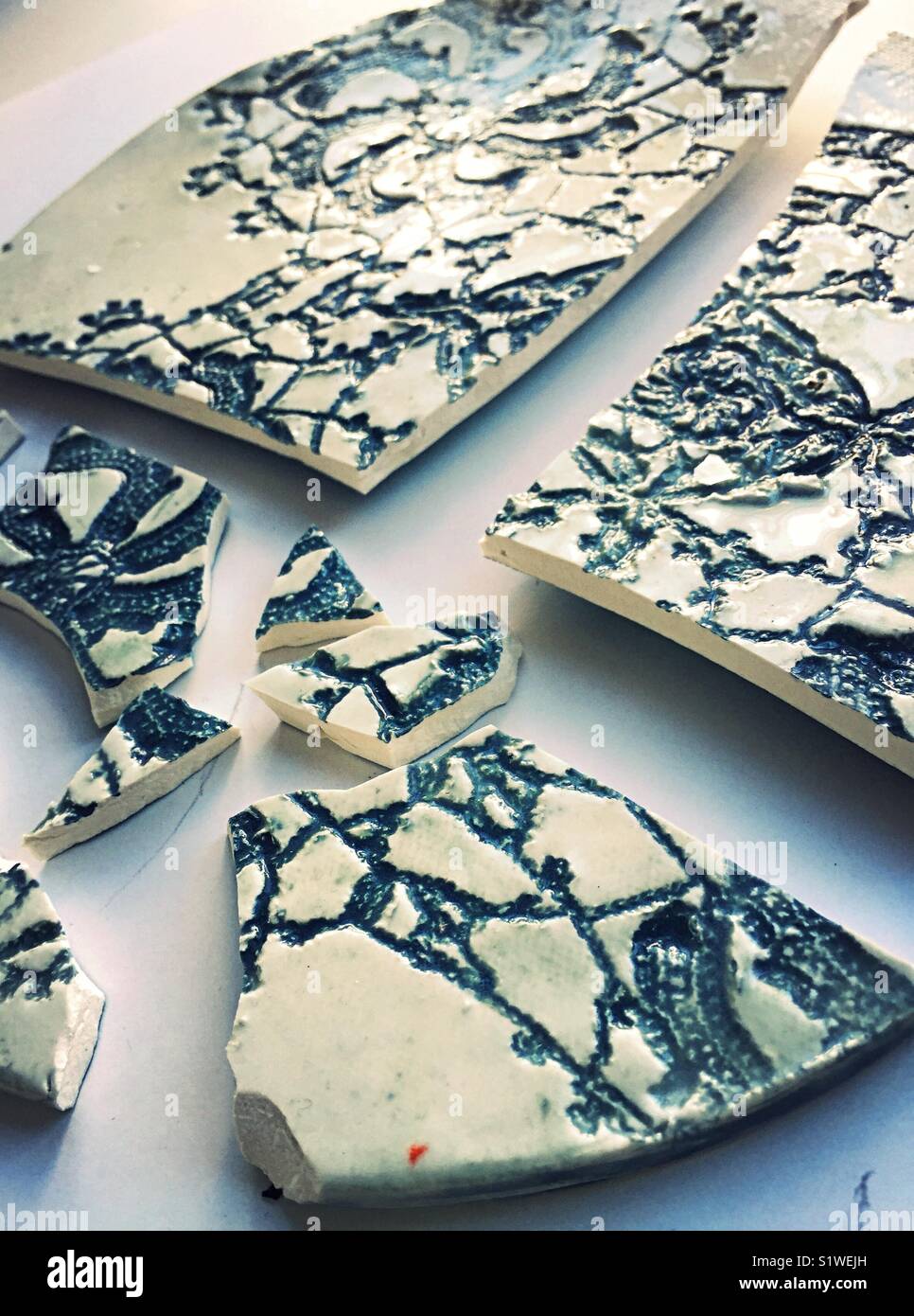 Broken hand thrown lace pattern pottery plate Stock Photo - Alamy