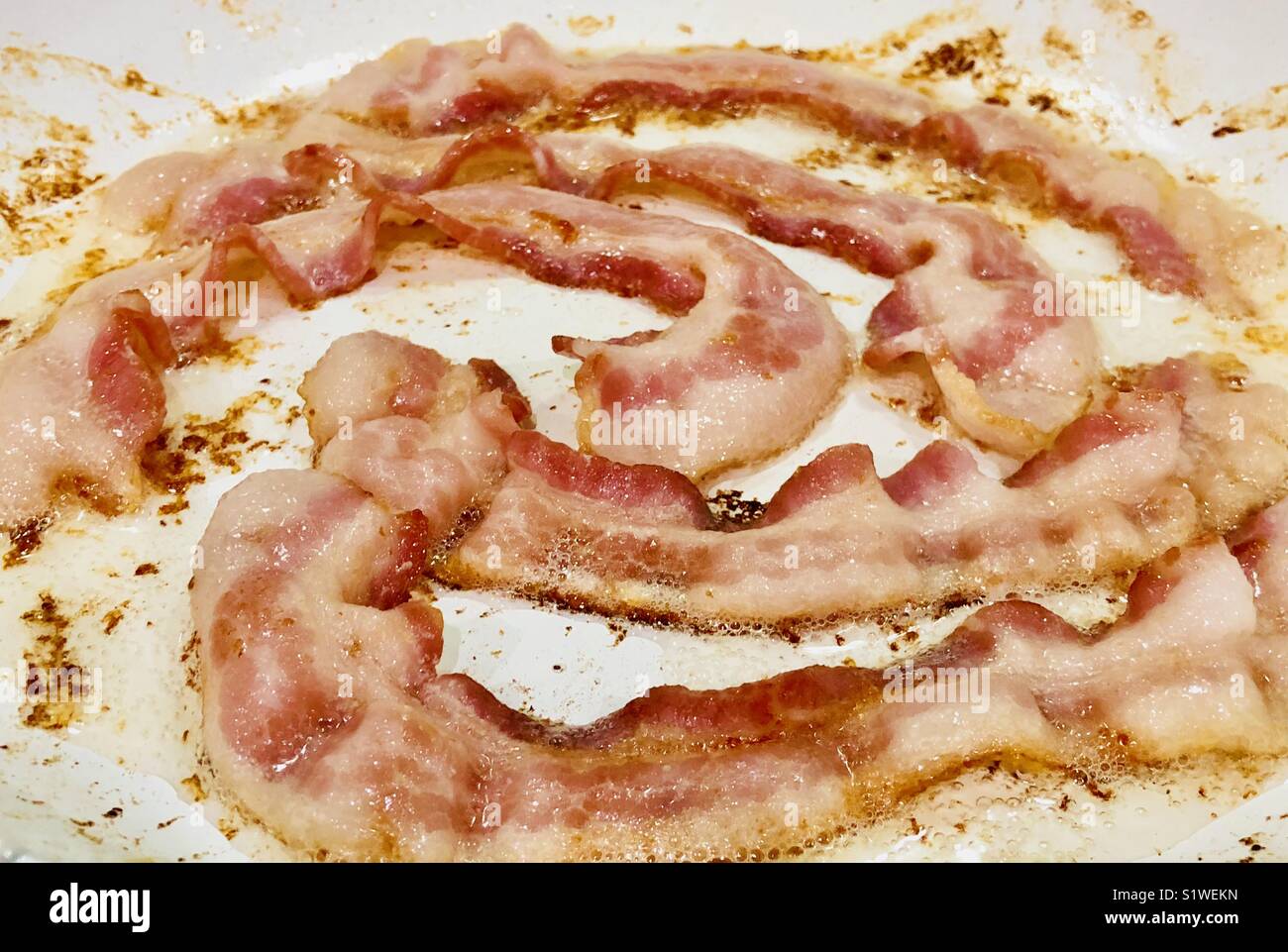 frying bacon on a pan Stock Photo - Alamy