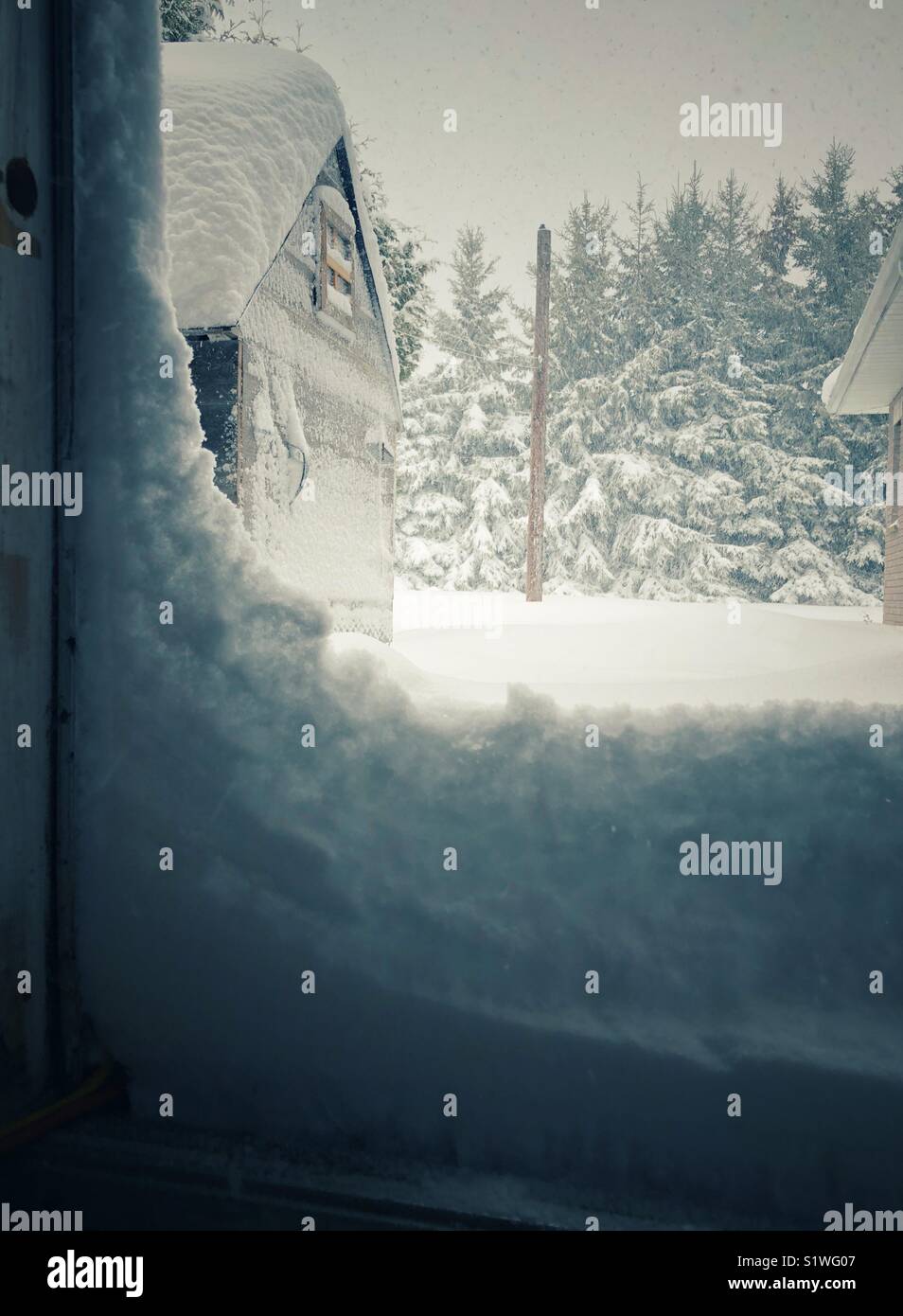 Looking out a doorway with deep snow rising up during a snowstorm in ...
