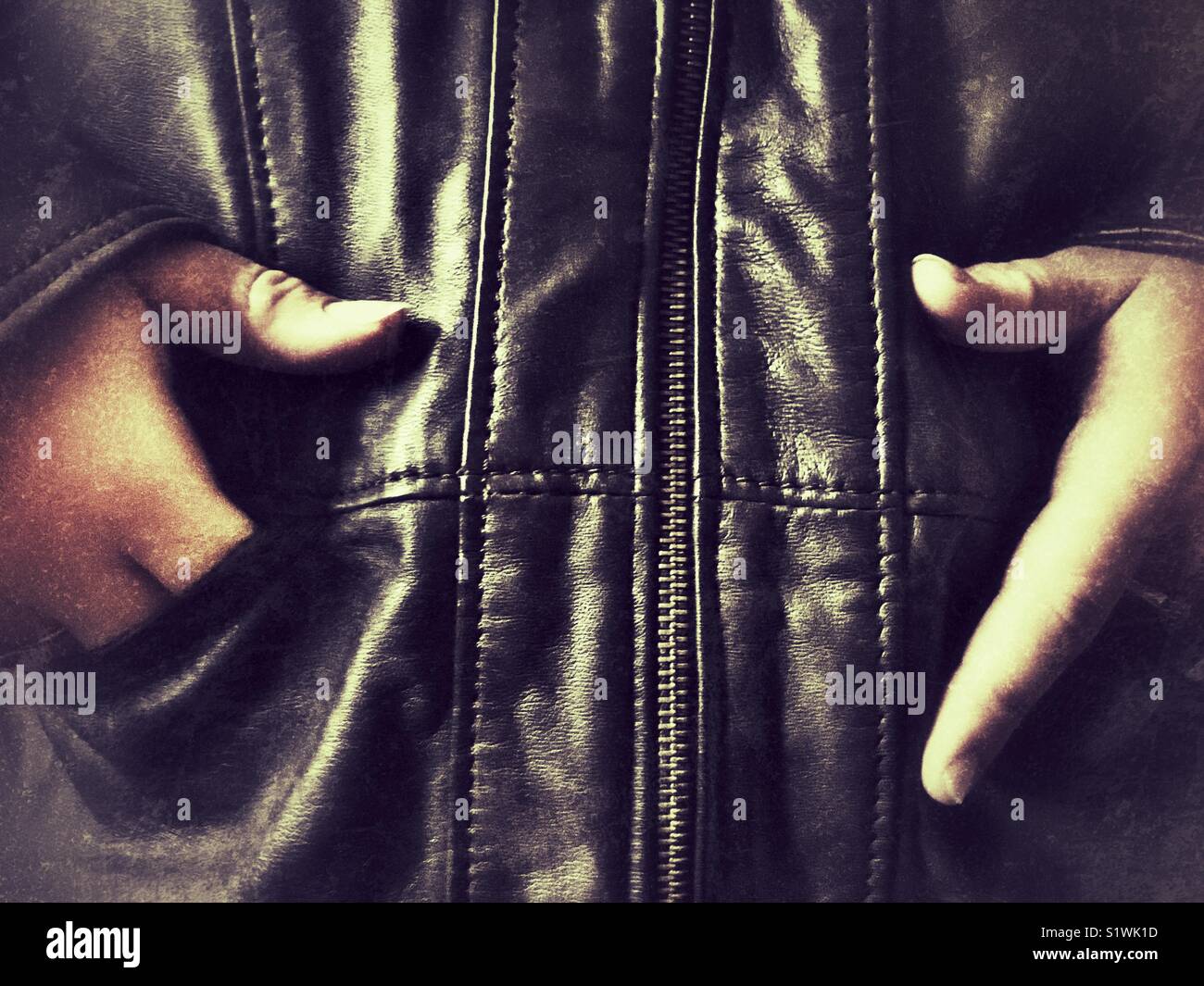 Woman wearing a brown leather jacket, hands in pockets, midsection ...