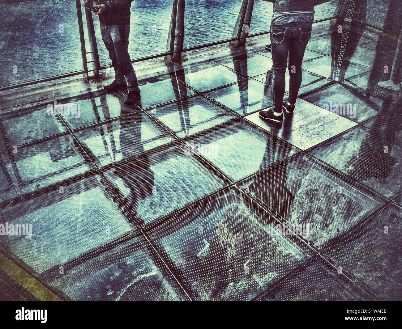 People standing on the glass skywalk viewing platform 580m above the ...