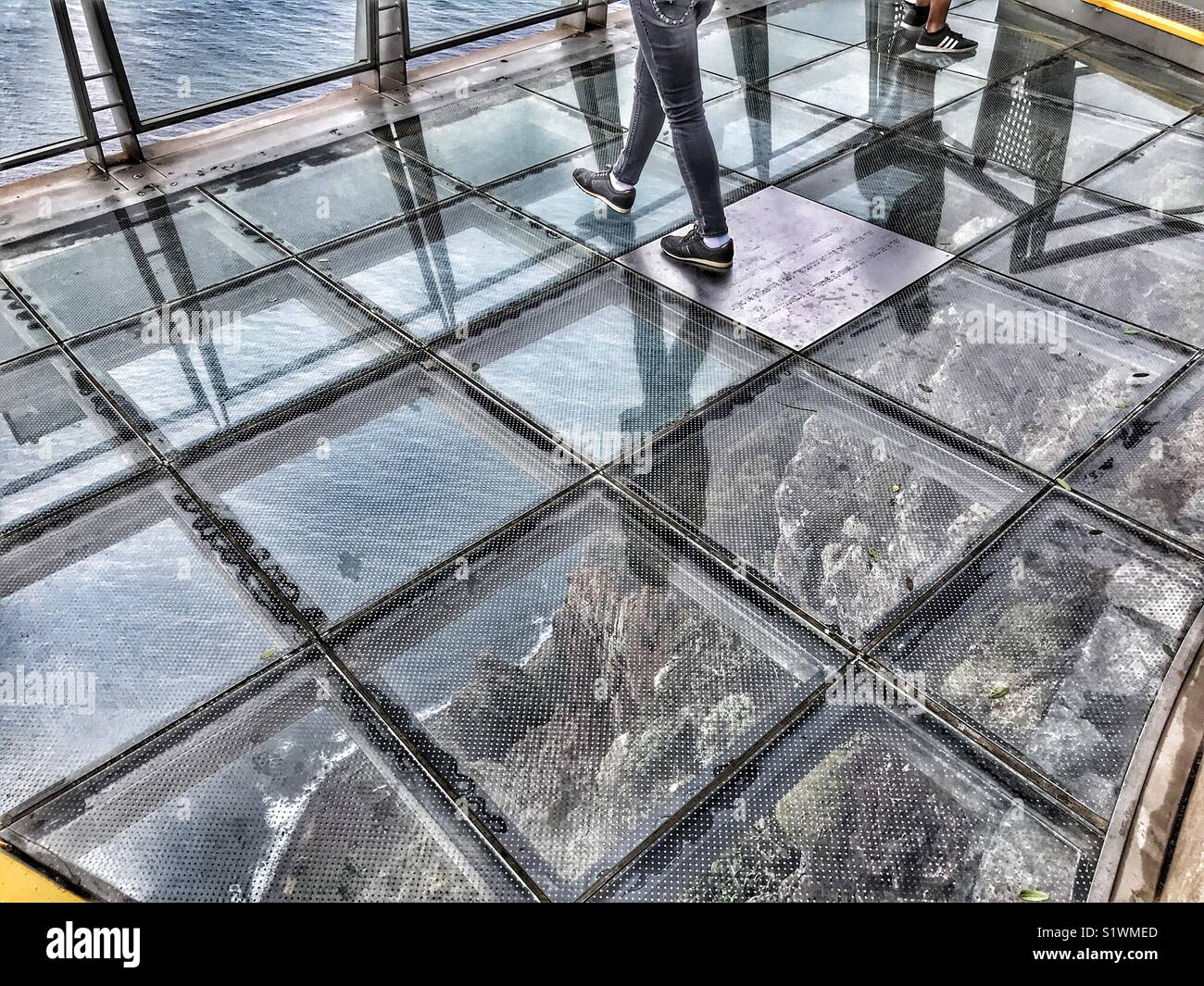 People standing on the glass skywalk viewing platform 580m above the ...