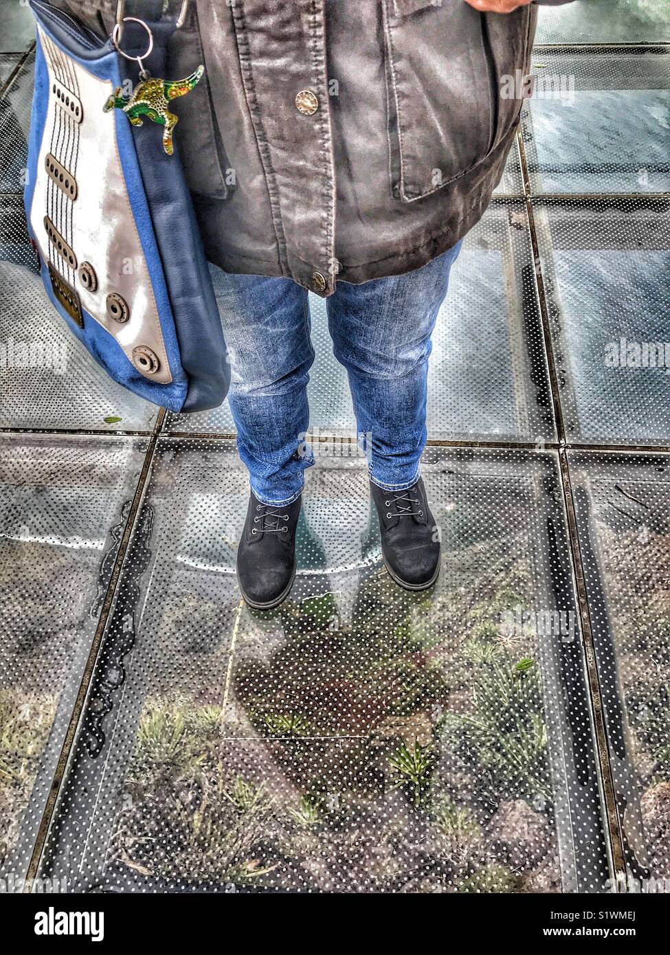 Woman standing on the glass skywalk viewing platform 580m above the sea ...