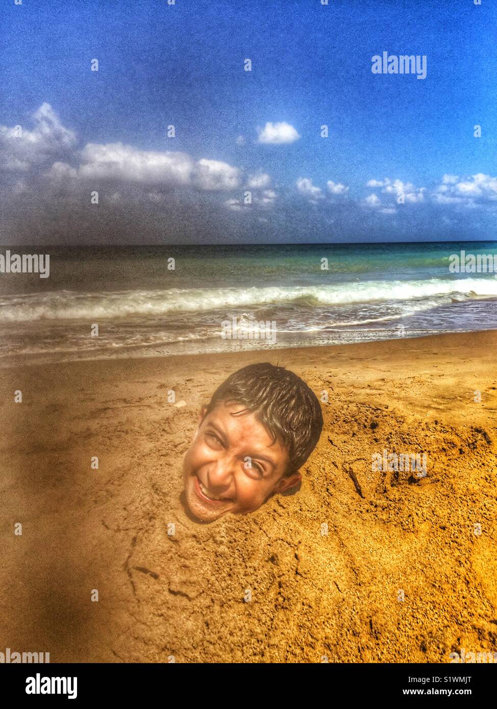 Boy buried in sand hi-res stock photography and images - Alamy