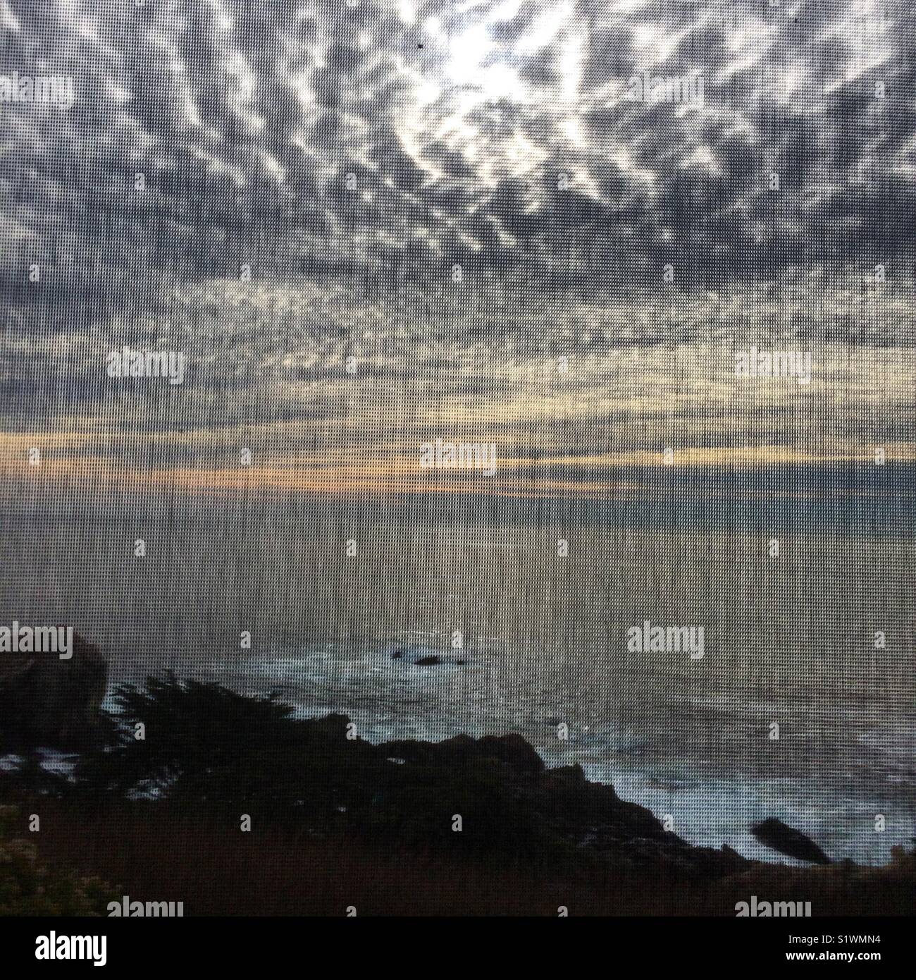 Looking out on the Pacific Ocean from behind a sun-blocking blind ...