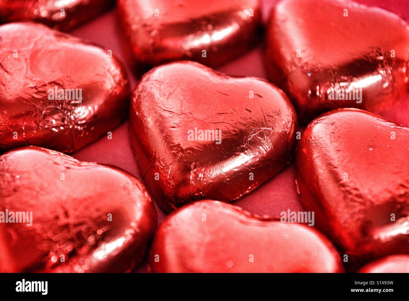 Heart shaped chocolates wrapped in red foil Stock Photo - Alamy