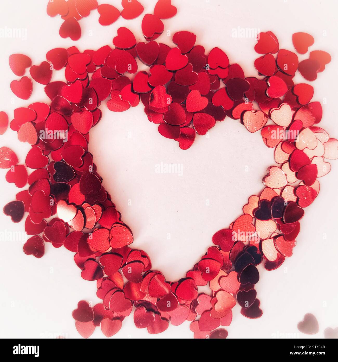 Red heart shaped sprinkles making a heart shape on white Stock Photo ...
