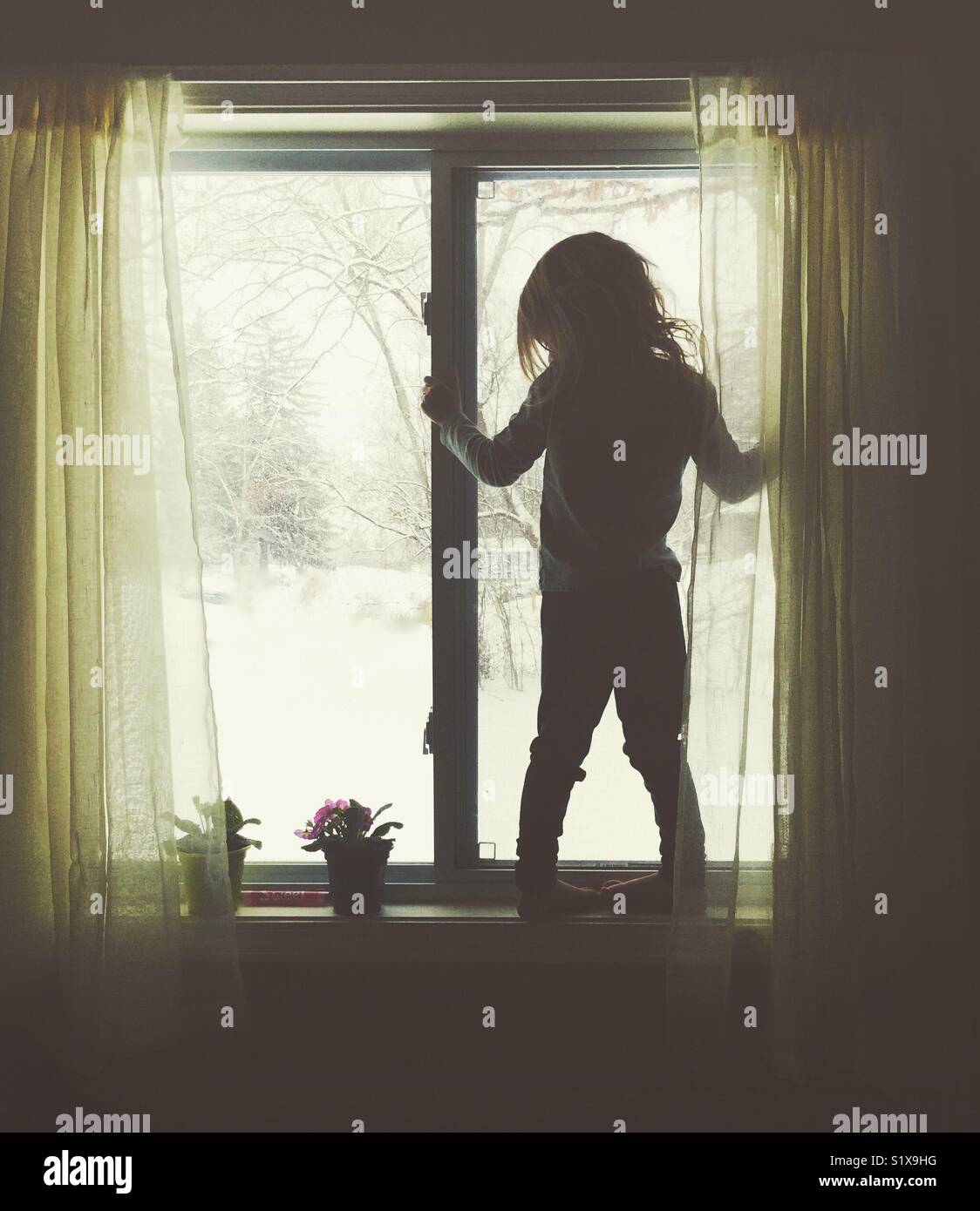 Young child standing in a window frame Stock Photo - Alamy