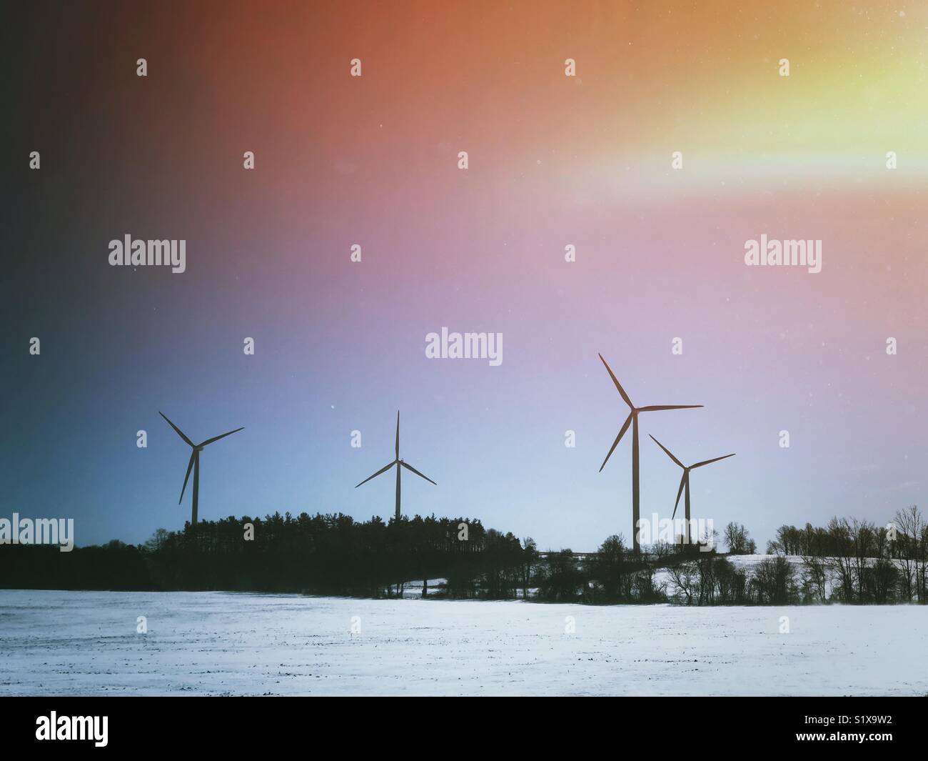 Four wind turbines with forest and snow below in Orono, Ontario Canada ...