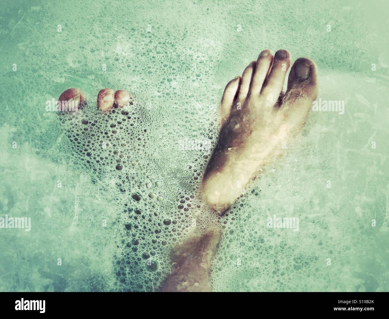 Crossed Feet In A Bubble Bath Partially Sticking Out Of The Water Stock