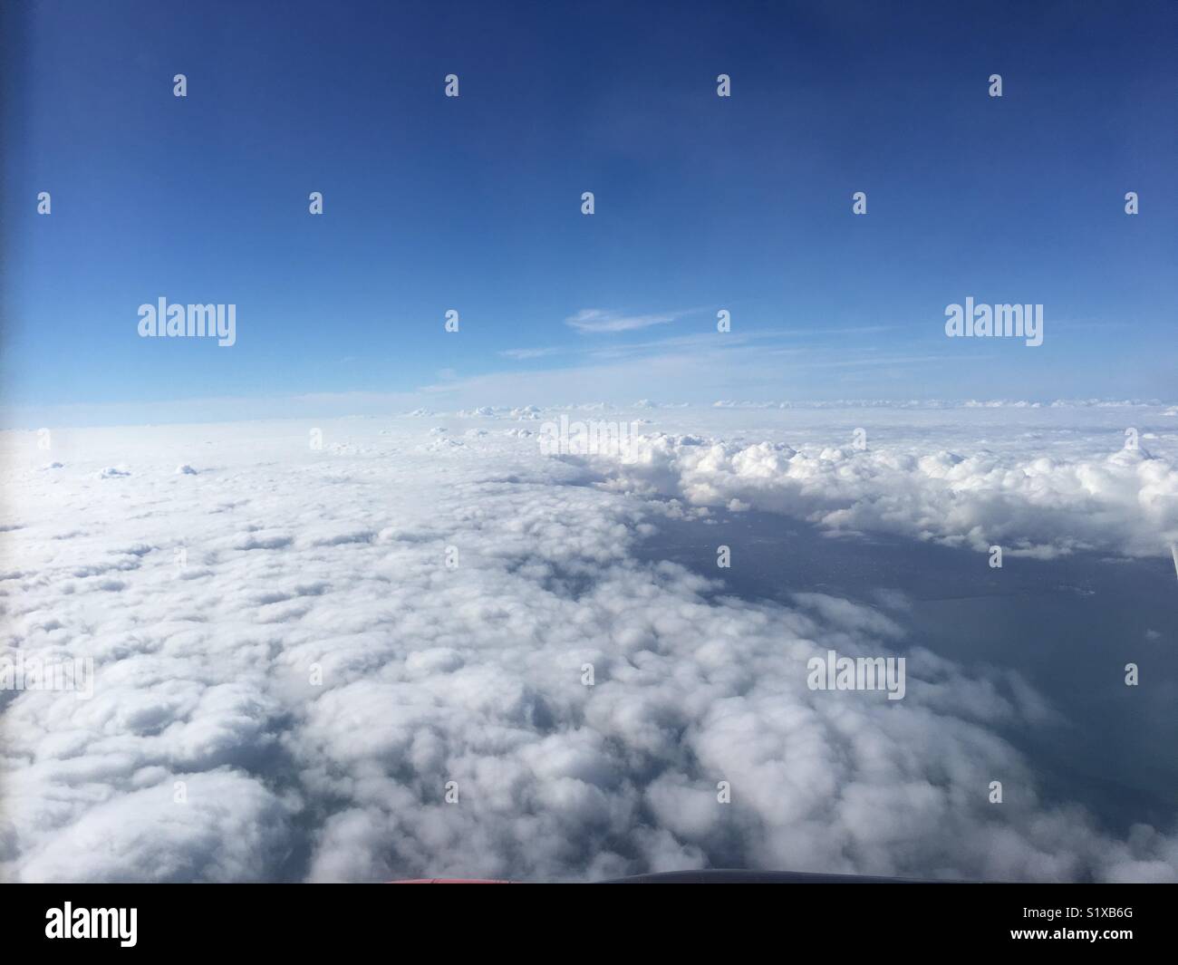 Over the clouds view from plane window Stock Photo - Alamy