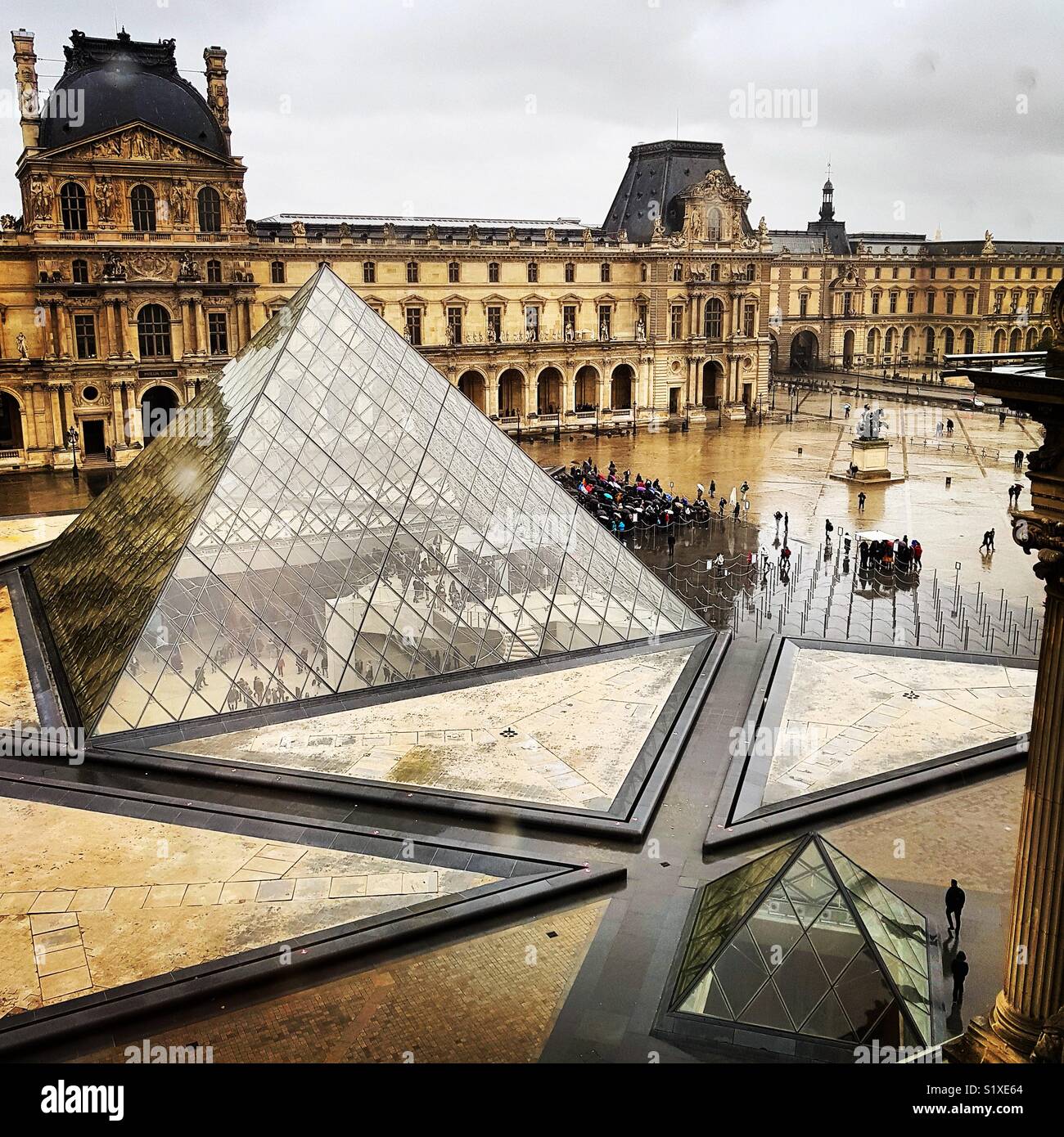 Visitors at Pyramide of Le Louvre Museum during a rainy day, Paris ...