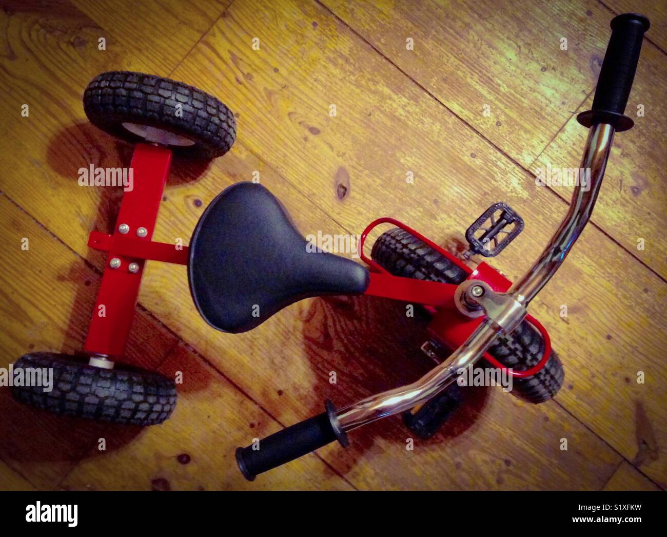 Red trike on wood plank floor Stock Photo - Alamy