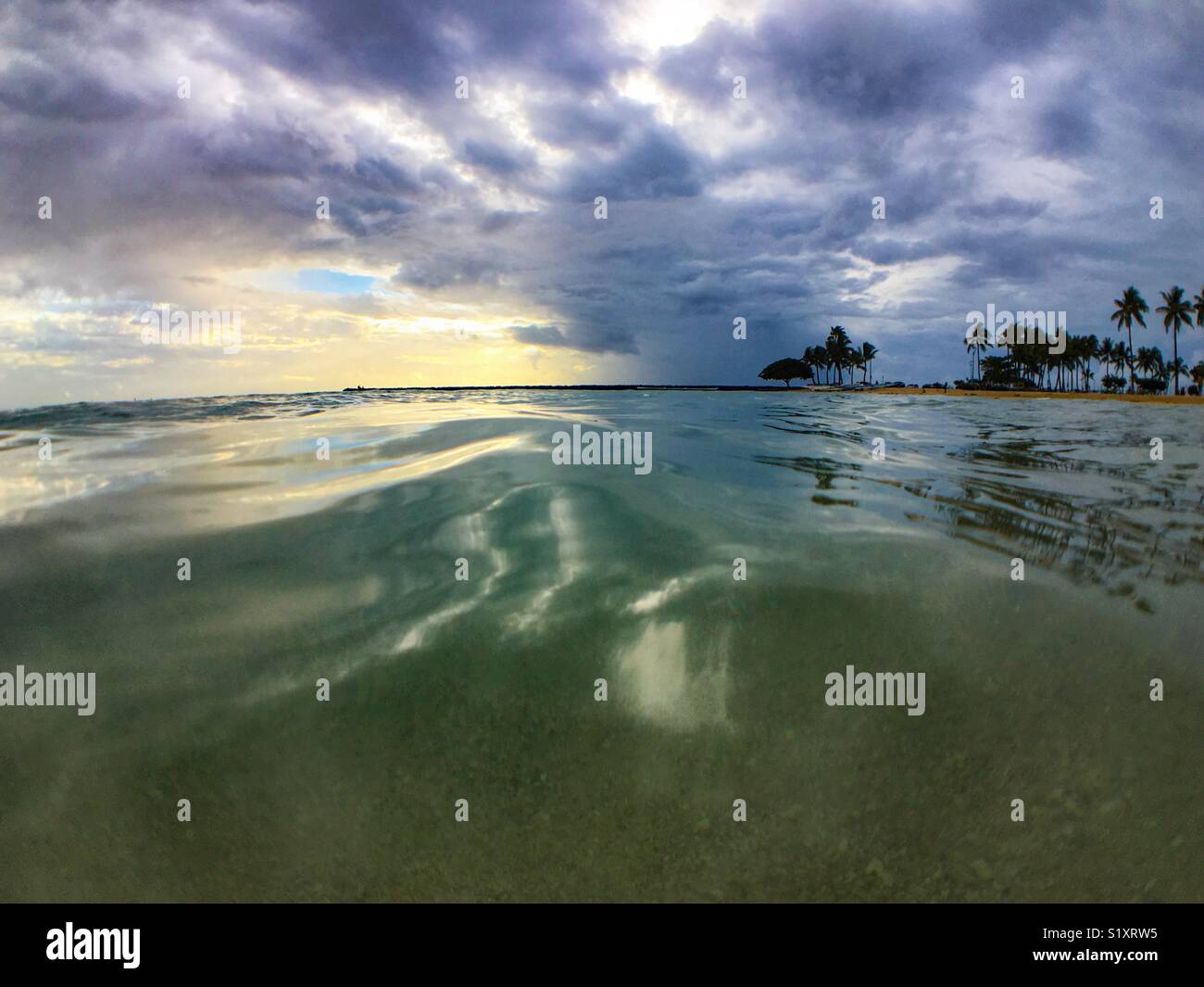 Seascape at sunset. Overcast skies over the warm Pacific Ocean with ...