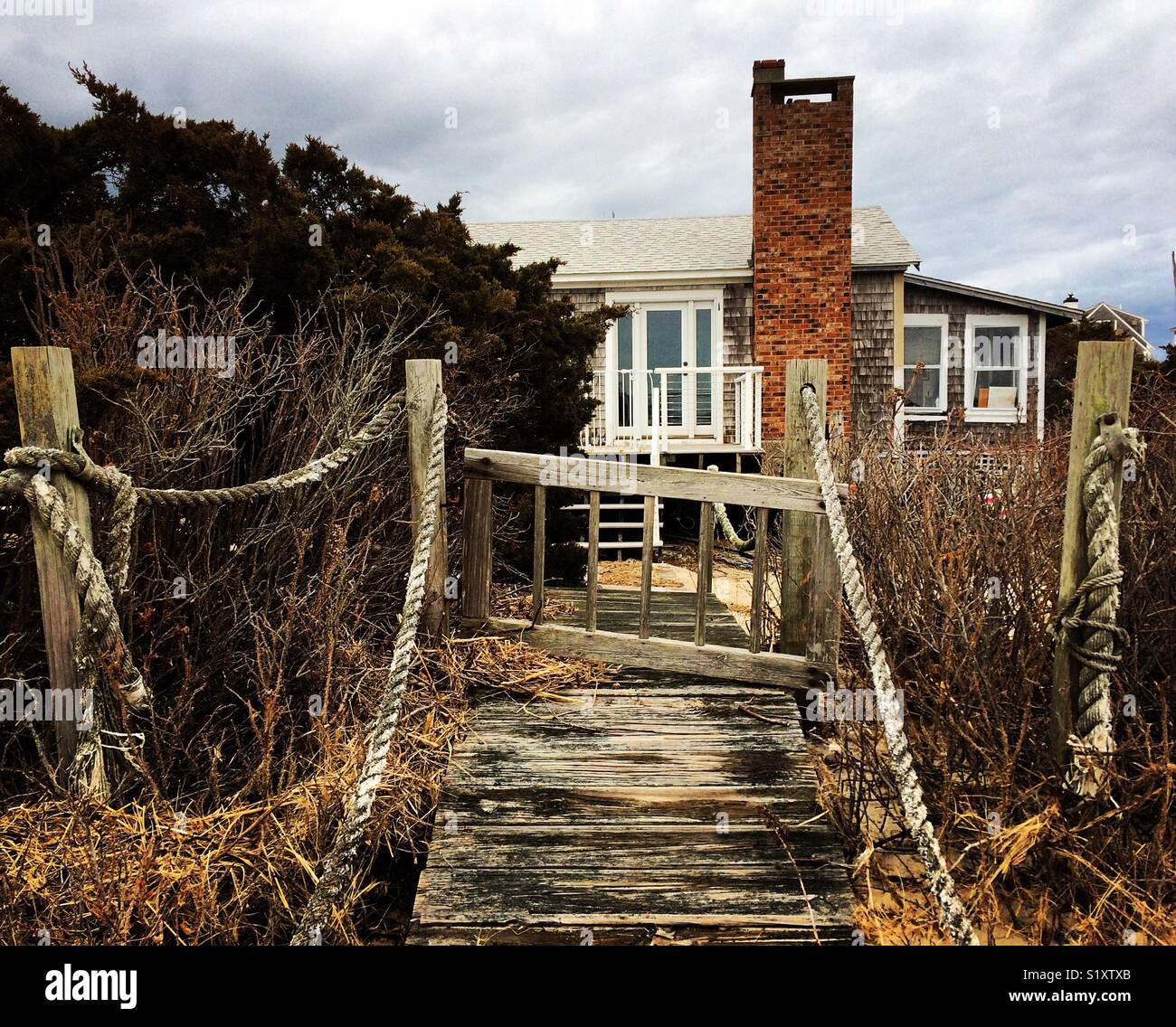 Walkway towards an old cottage near the beach on Cape Cod ...