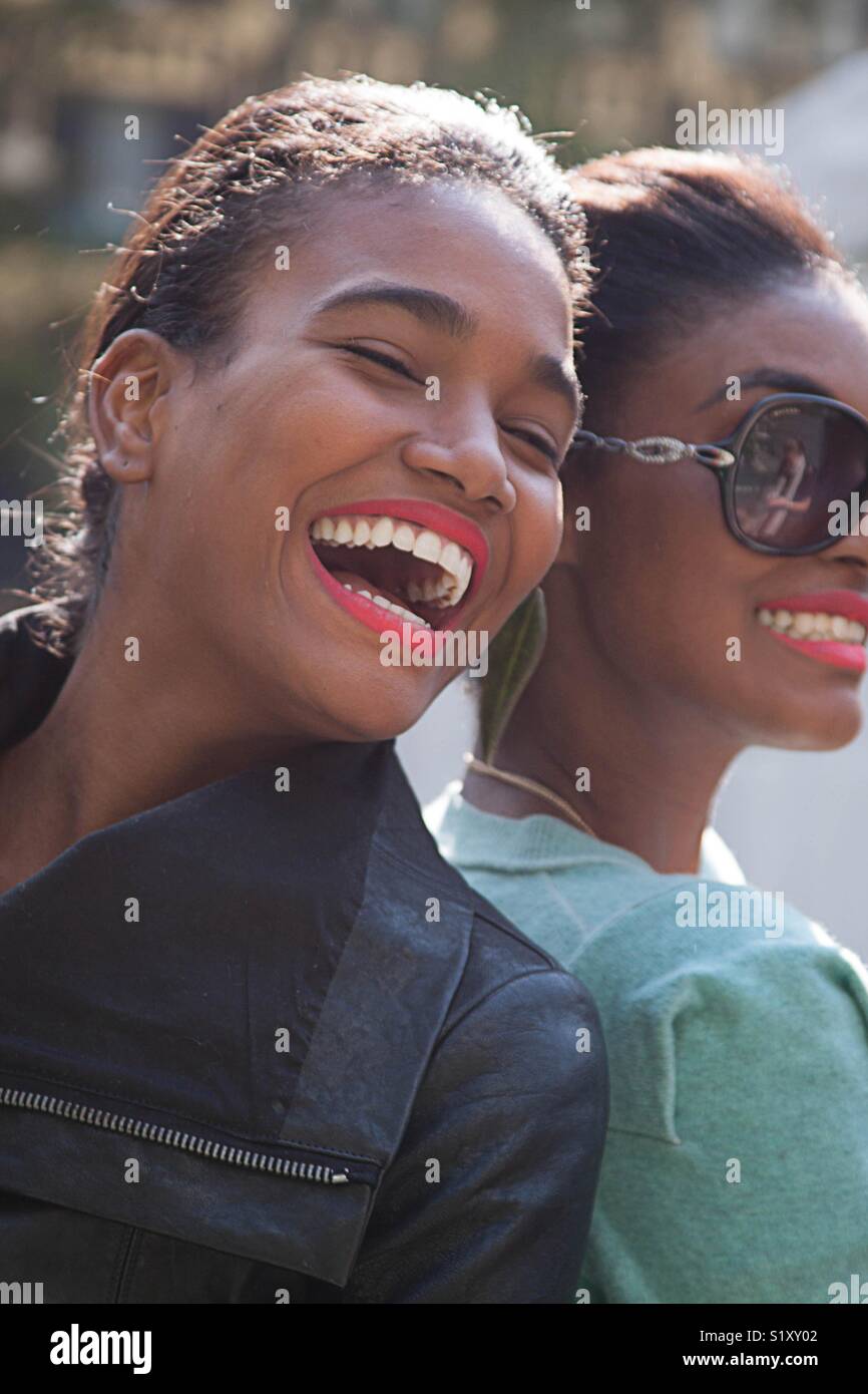 Two Fashion models laughing outdoors Stock Photo - Alamy