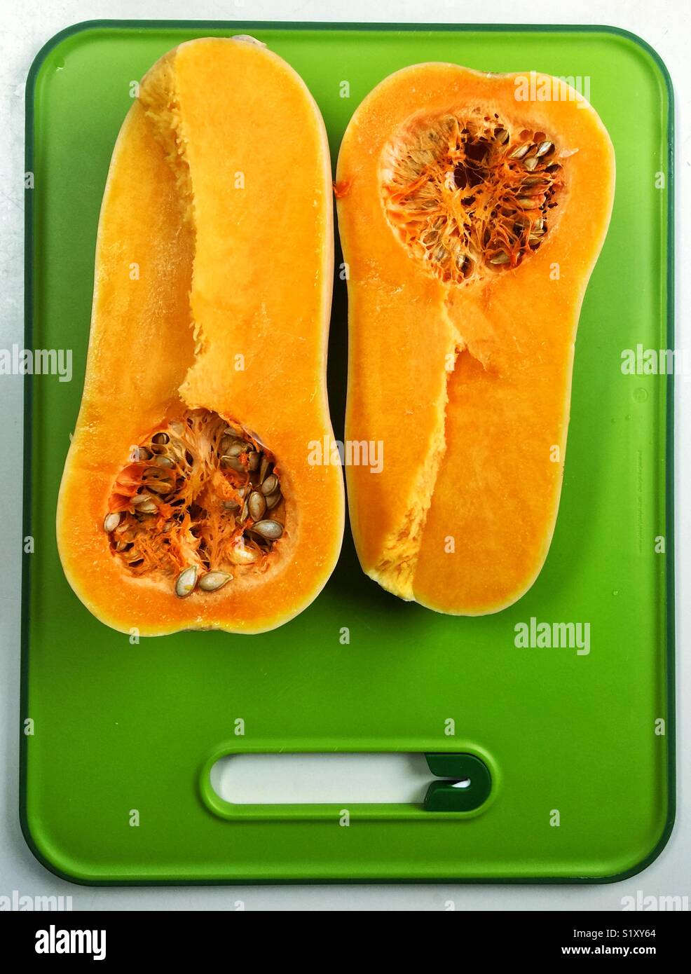 Two halves of butternut squash on green cutting board Stock Photo - Alamy